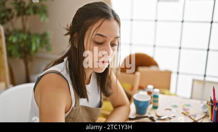 Serious faced woman drawing on a graphic tablet, looking at the big ...