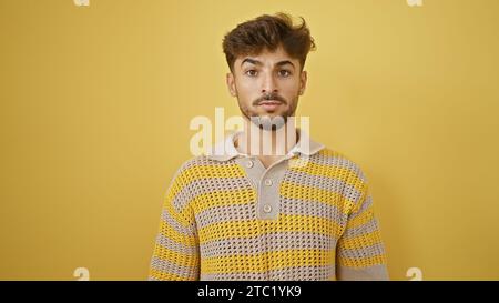 Stylish young arab man coolly bears his serious expression, standing ...
