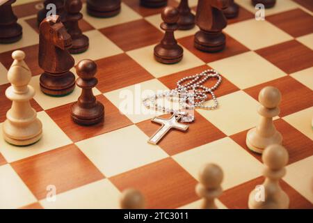 Catholic religious cross with chess pieces of kings on a chessboard ...
