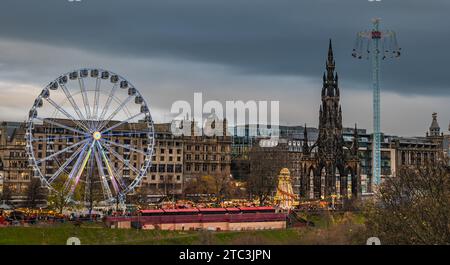 Big ferris wheel and star flyer fairground rides lit up at night at ...