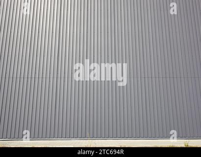Corrugated steel warehouse or factory industrial building against blue ...