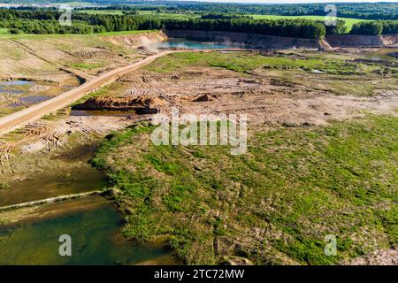 Drone view of the territory of an overgrown quarry with road ...