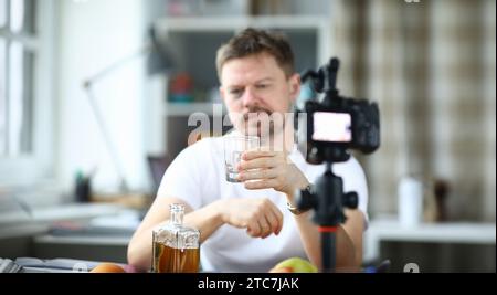 Exhausted man with black eye drinks alcohol in front of camera Stock ...