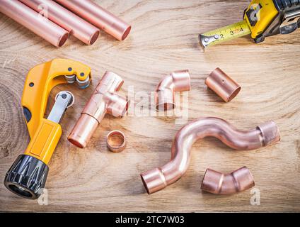 Collection of brass water pipe cutter fixtures tape measure on wooden ...