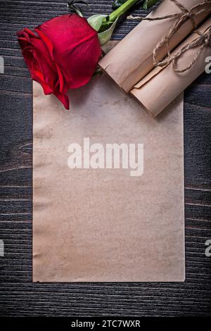Vintage corded paper rolls red expanded rose on wooden board Stock ...
