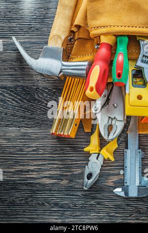 Brown leather toolbelt with construction tools on wood board directly ...