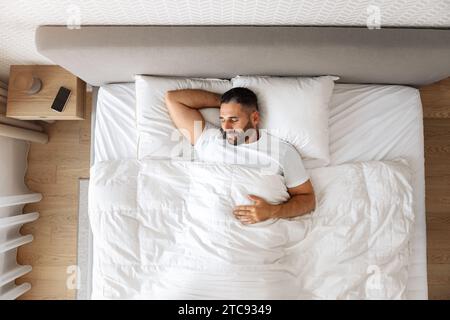 Top view of sleeping guy enjoying restful nap in bedroom Stock Photo ...