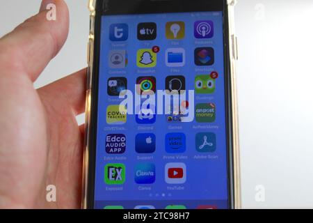 A close up photo of someone scrolling on the apps on their iPhone ...