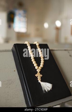 rosary with cross on the bench in the church Stock Photo - Alamy