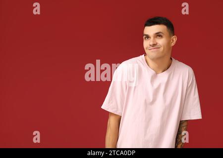 Handsome ashamed young man shrugging on lilac background Stock Photo ...