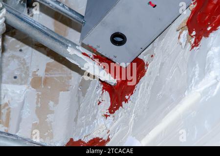 Red firestop sealant on firerated wall next to electrical conduit Stock ...