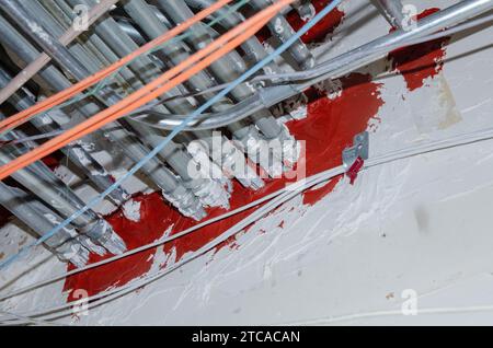 Red firestop sealant on firerated wall next to electrical conduit Stock ...