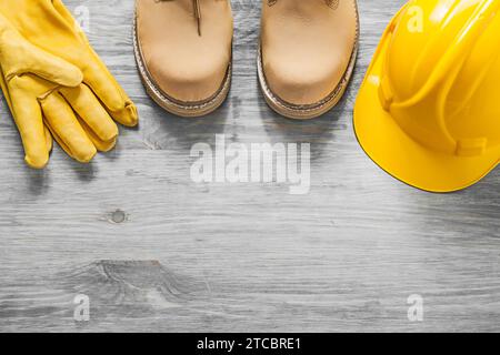 Waterproof lace boots building helmet protective gloves on wooden board ...
