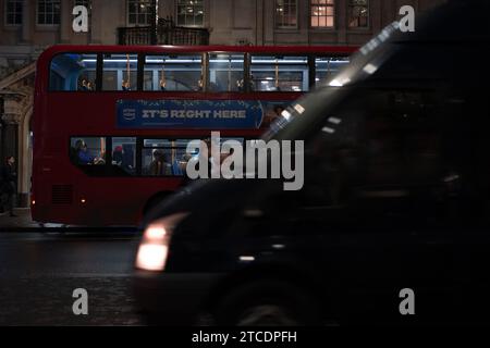 A classic red bus navigates through the winter streets of London ...