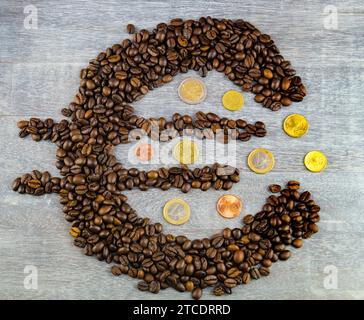 Euro sign, formed with roasted coffee beans, with Euro coins, coffee ...