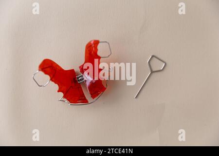 Red retainer or jaw expander on the background. Crooked teeth ...