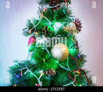 Boy's Christmas tree decorated with golden ornaments in a beige ...