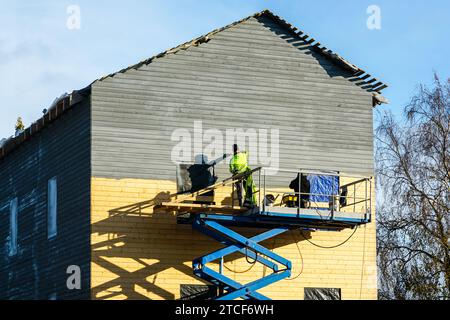 Residential house facade painting works after cladding with wooden ...