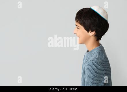 Little Israeli boy in kipa on grey background, back view Stock Photo ...