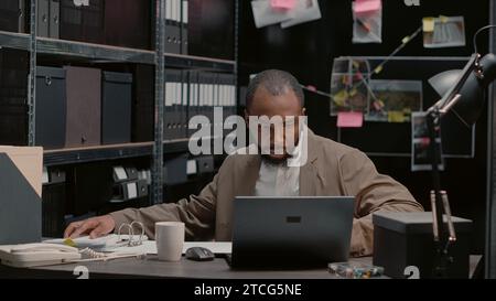 African american law agent putting clues on board, trying to conduct ...