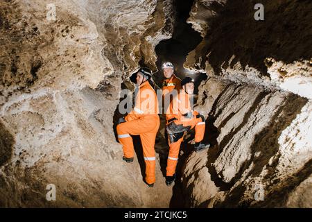 Three men, strong physique, explore the cave. Men dressed in special ...