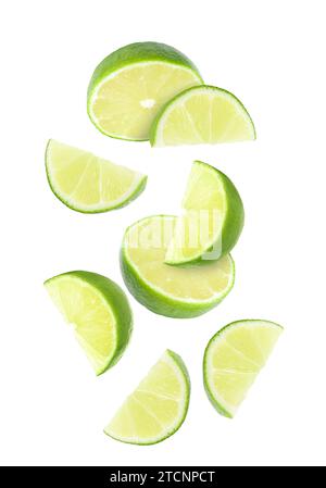 Cut fresh limes falling on white background Stock Photo - Alamy