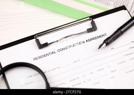 Construction contract form on A4 tablet lies on office table with pen ...
