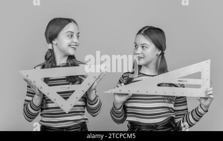 cheerful school kids hold math tool of triangle Stock Photo - Alamy
