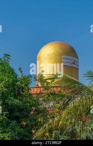 Top of a golden color Lord Shiva Lingam temple in Puttaparthi with ...