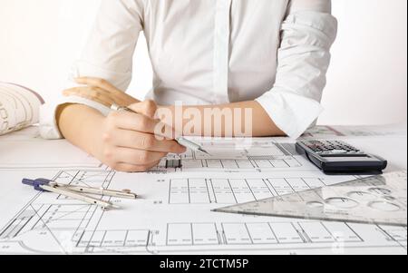 Female engineer designing architectural blueprints at office desk Stock ...