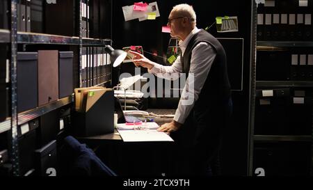Private inspector reviewing clues on wall map Stock Photo - Alamy