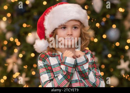 Kid praying, kids prayer. Happy funny child in Santa hat near Christmas ...