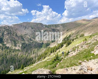 A lone hiker on a trail with stunning canyon views and rugged rocky ...