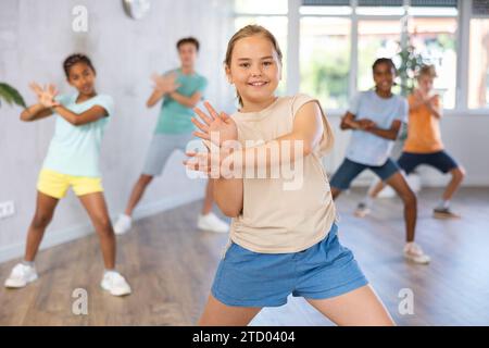 Energetic tween girl practicing vigorous movements in children dance ...