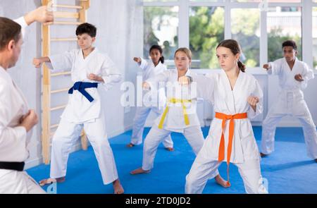 Girl with group of tweens performing kata routines during karate ...