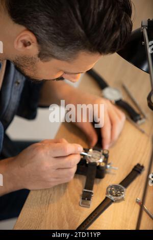 Man fixing mechanism of vintage wrist watch at table, closeup Stock ...