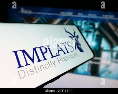 Mobile phone with website of company Impala Platinum Holdings Limited (Implats) in front of ...