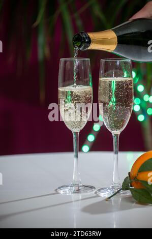Pouring of brut champagne, cava or prosecco dry wine in glasses with ...