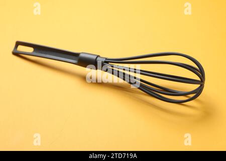 Plastic whisk on yellow background, top view. Kitchen tool Stock Photo ...