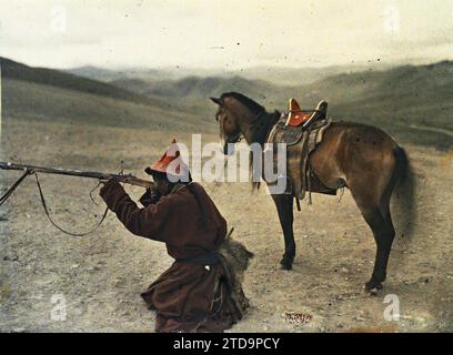 Around Ourga, Mongolia a Mongolian hunter on horseback and armed with a ...