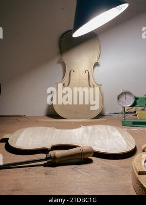 raw new violin top plate and back plate carving on violin maker desk ...