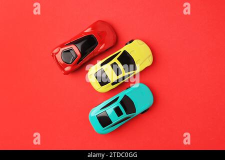 Different bright cars on red background, flat lay Stock Photo - Alamy