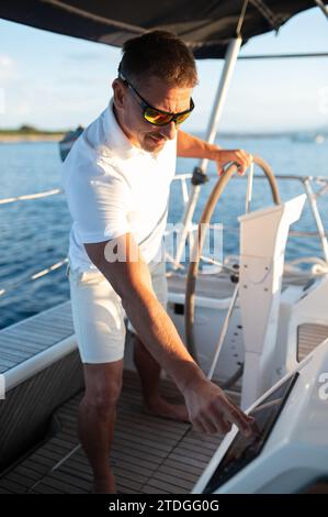 Man in white clothes sailing on a yacht Stock Photo - Alamy