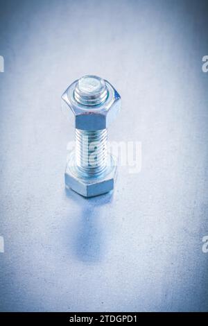 Detail of a stainless steel bolt with threaded nut on a chequer plate ...