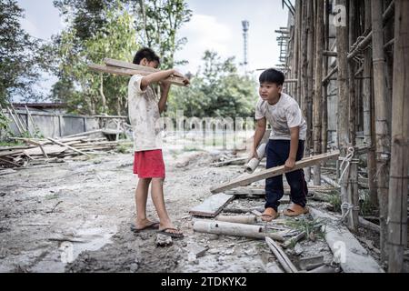Children forced to work hard at construction site, child labor concept ...