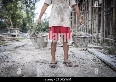 Children forced to work hard at construction site, child labor concept ...