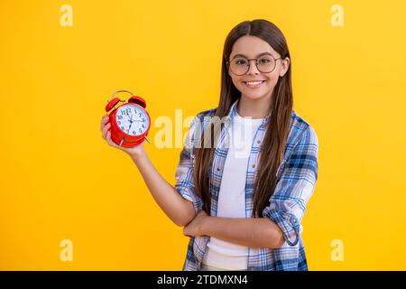 Teen girl organizing her schedule with a clock. Teen girl hold alarm ...