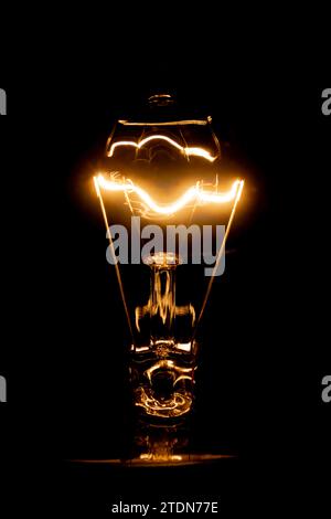 Closeup of the light bulb filament glowing in the darkness Stock Photo ...