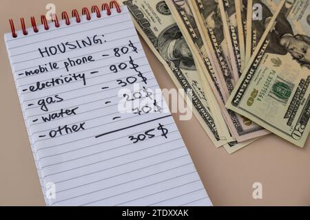 Dollar cash money with notebook handwritten housing expenses. Counting ...