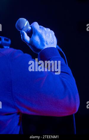 Dynamic singer performing under mesmerizing blue lights on stage Stock ...